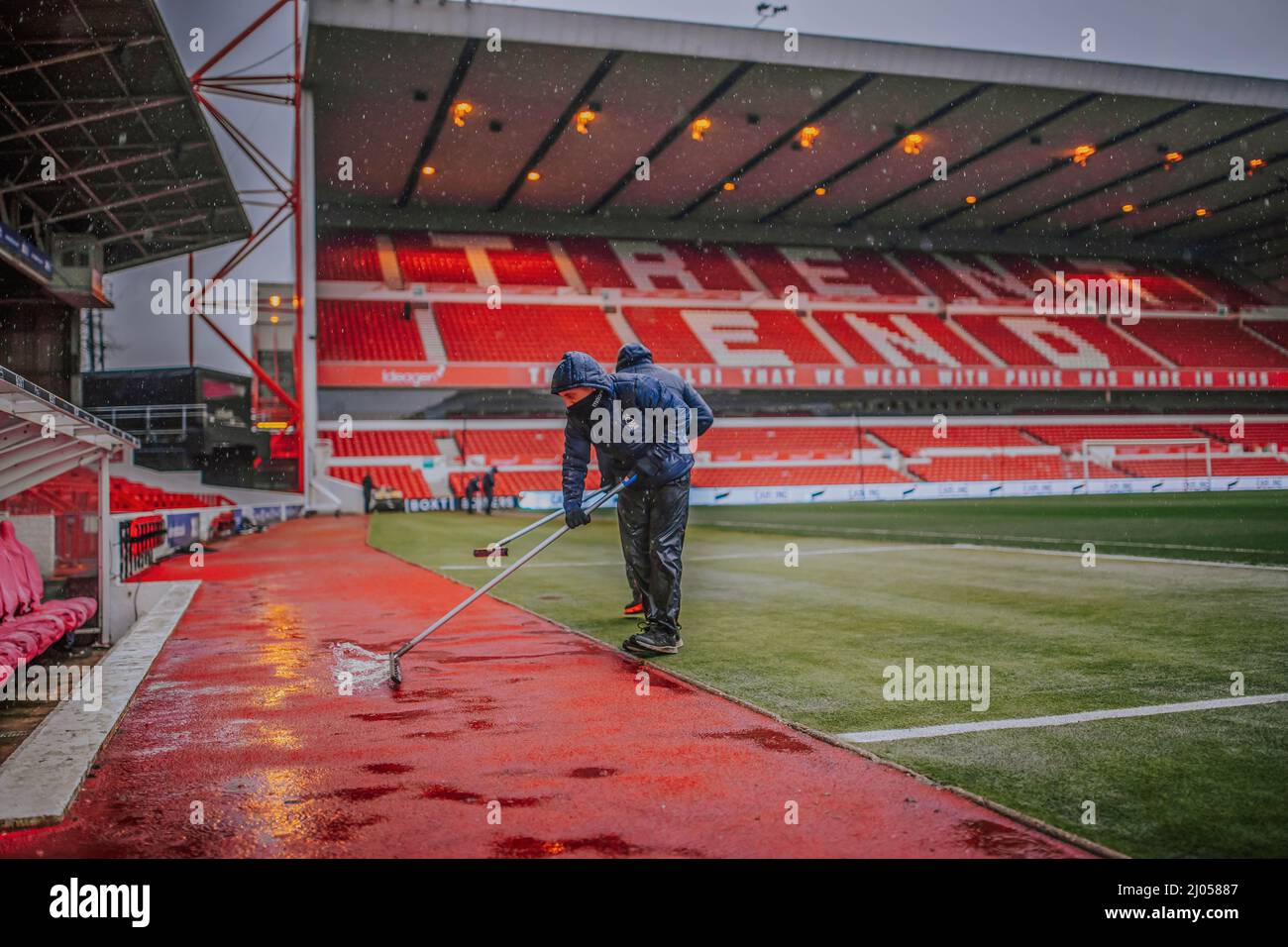 Ground staff clear the rain before kick off at The City Stock Photo - Alamy