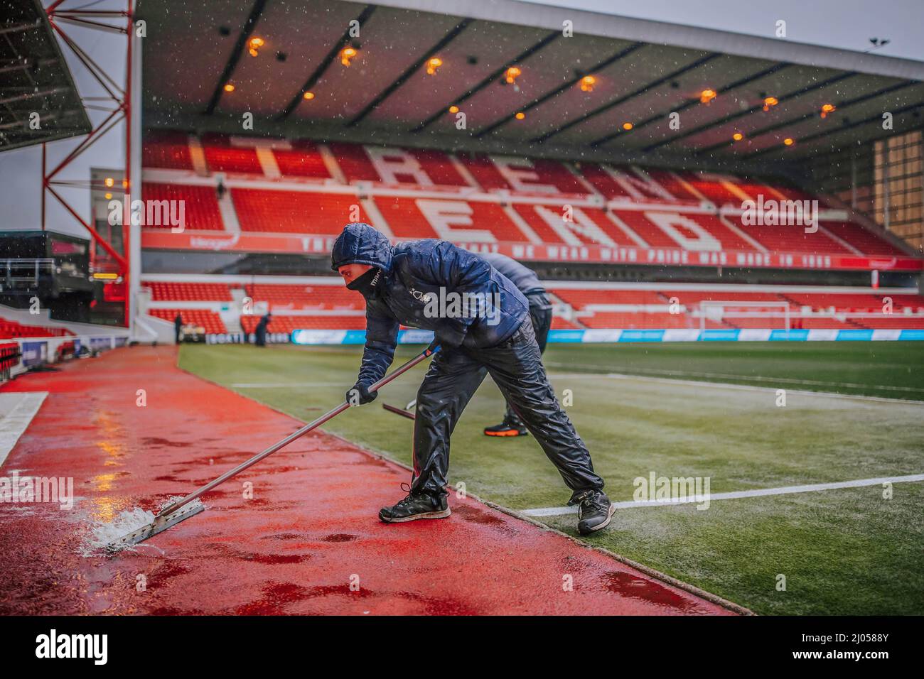 Ground staff clear the rain before kick off at The City Stock Photo - Alamy