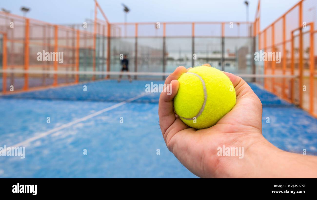 Monitor holding paddle tennis ball for teaching padel class to one ...
