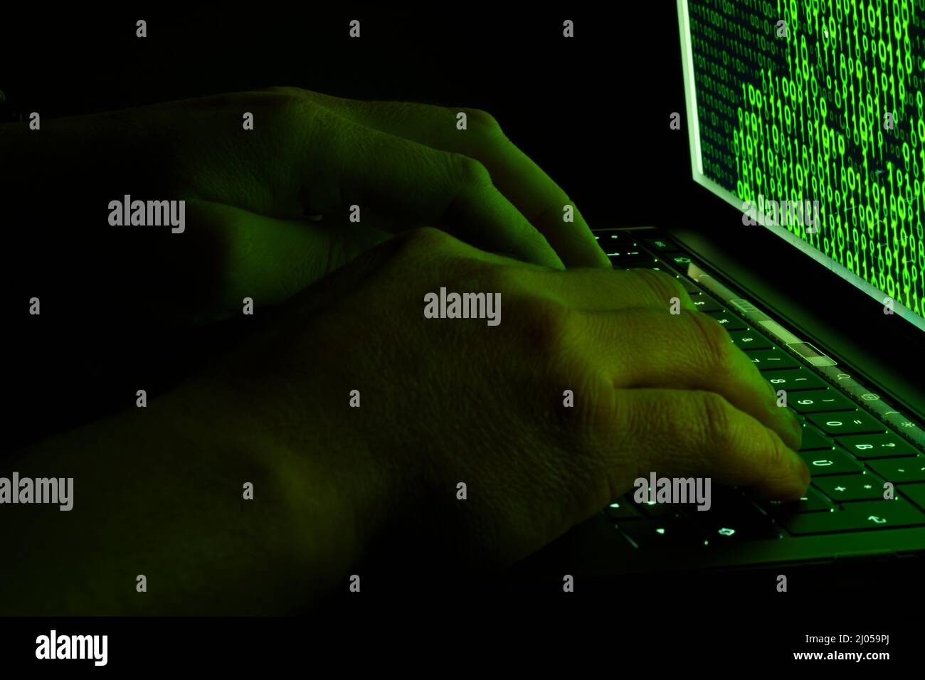 Hands on a notebook keyboard. Hacker Concept with Binary Code. Data leakage. Cyber attack ...
