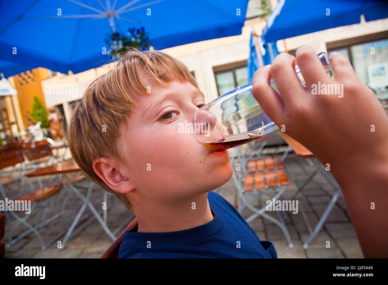 happy child drinks non alcoholic drinks out of a beer glass and enjoys ...