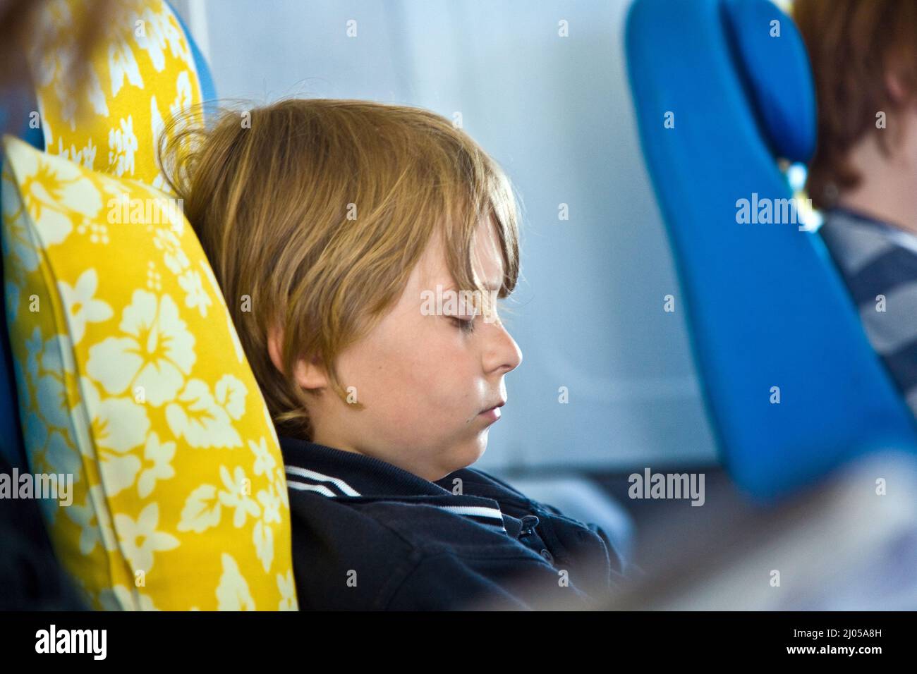 young passenger sleeping in the business class Stock Photo - Alamy
