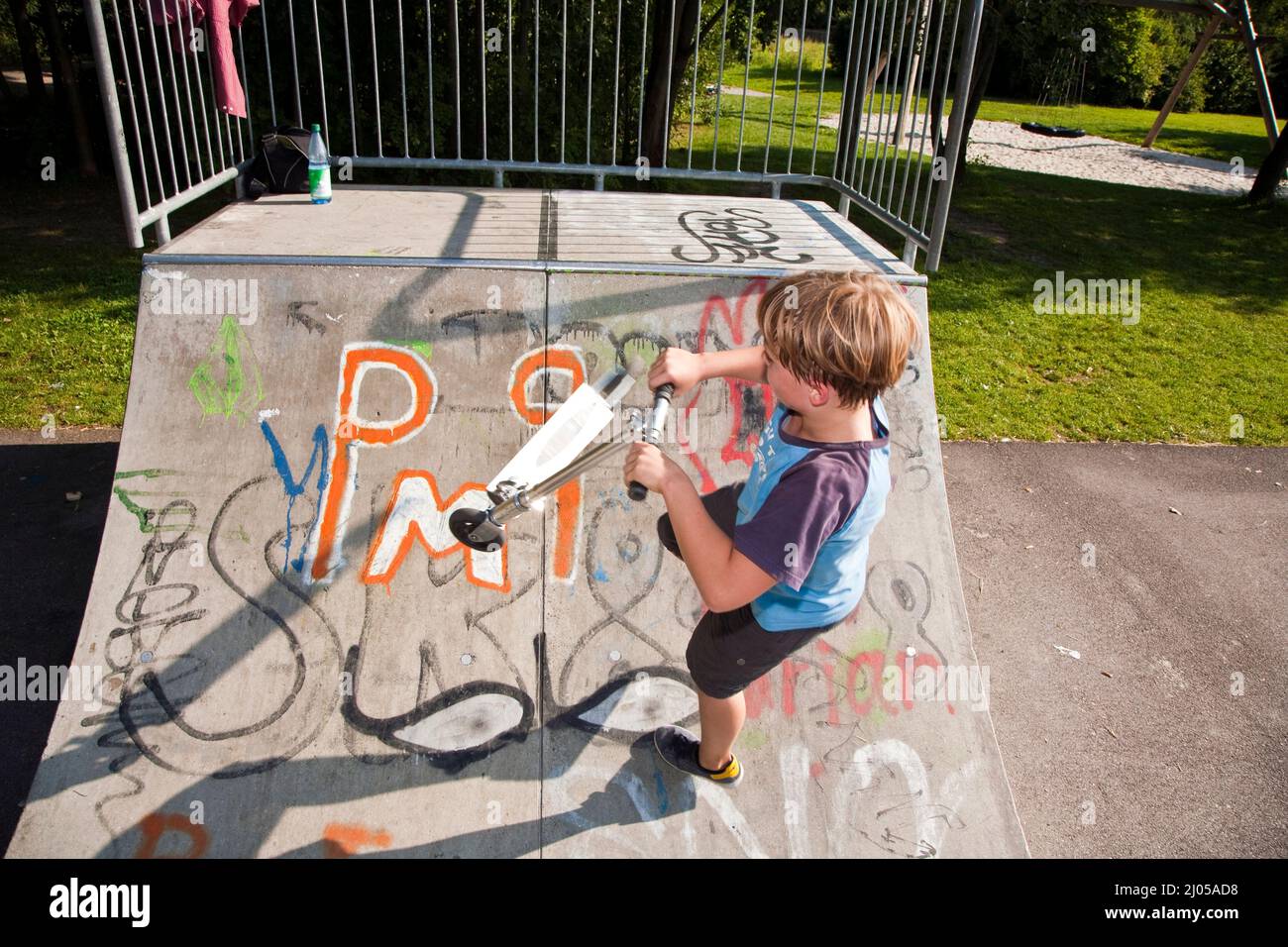 boy has fun scooting in the scating at the skatepark Stock Photo - Alamy