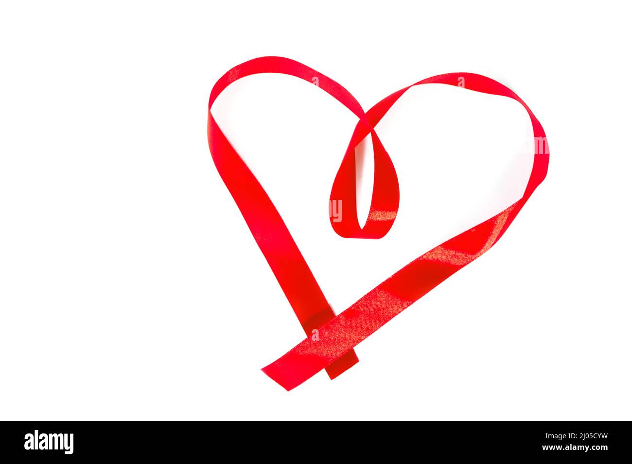 Red heart shaped ribbon on a white background. The concept is love in ...