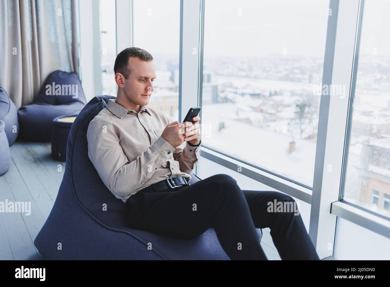 Successful male freelancer sitting in modern workspace and checking ...