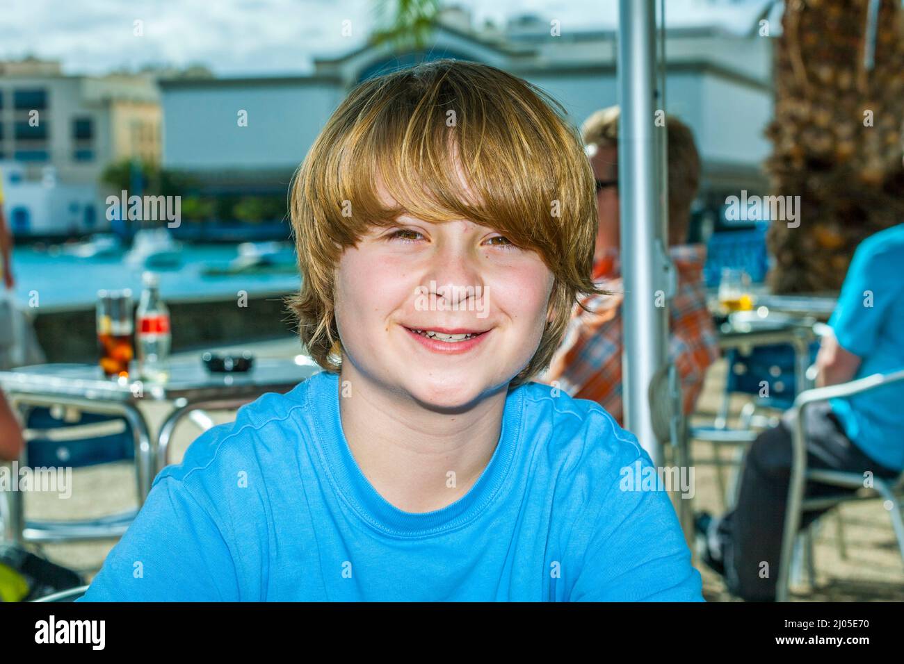 outdoor portrait of relaxed cute young boy looking positive and ...