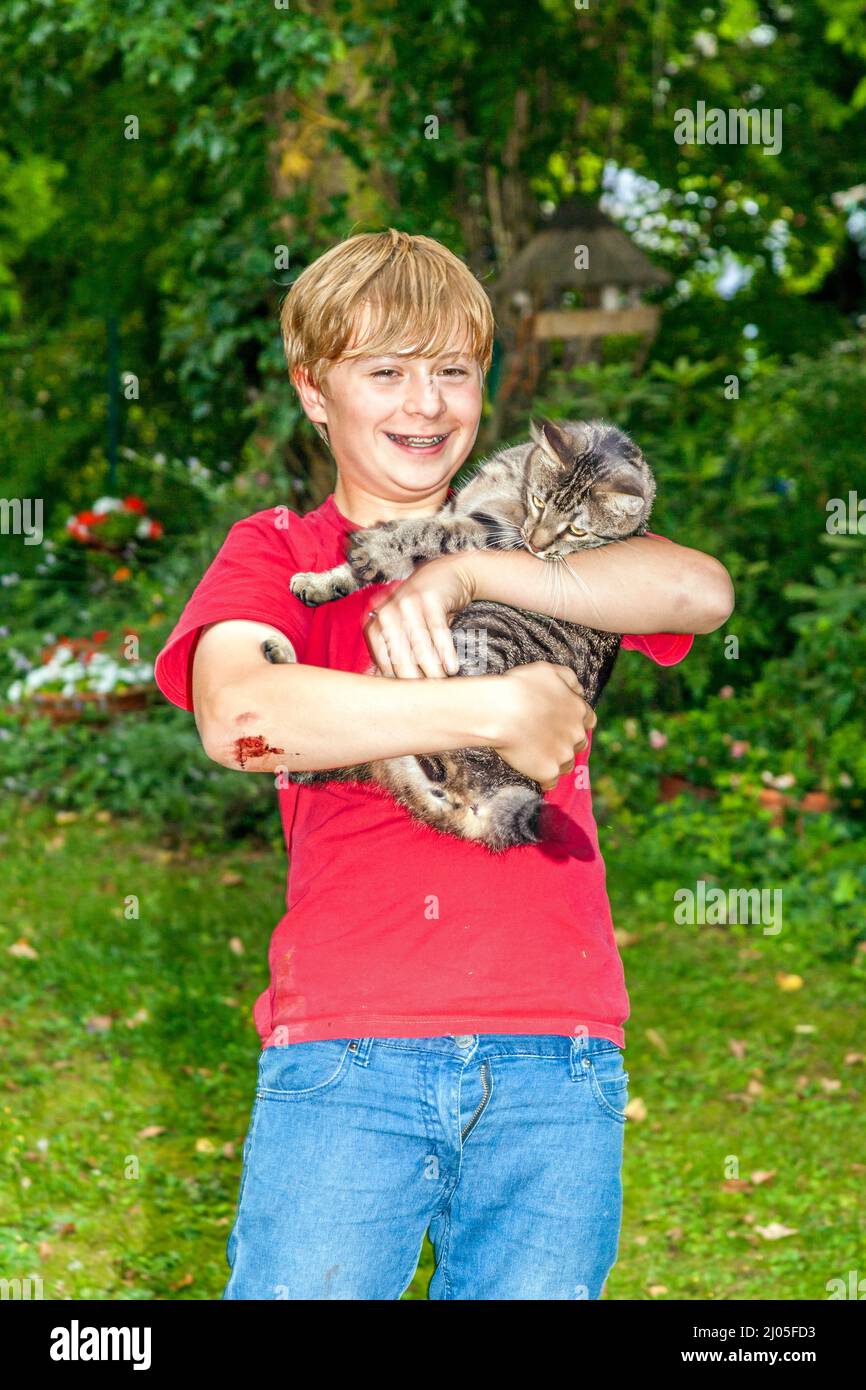 cute boy holding his cat in the arm Stock Photo - Alamy