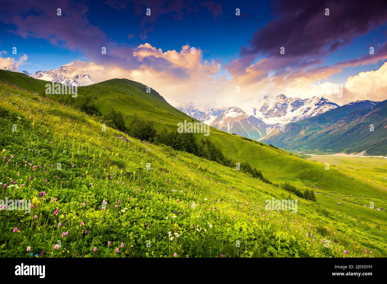 Fantastic colorful sunset at the foot of Mt. Shkhara. Dramatic overcast ...