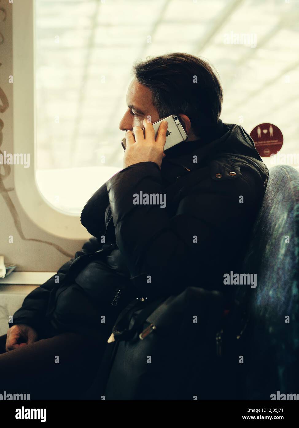 Side view of a businessman talking to the phone in the metro in ...