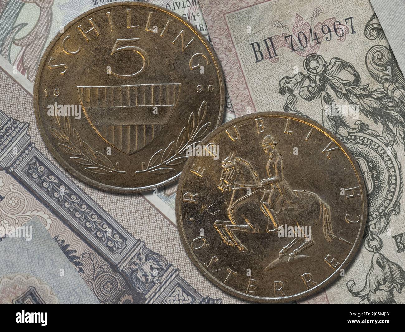 Closeup of an old Austrian coin (5 schilling) on banknotes background ...