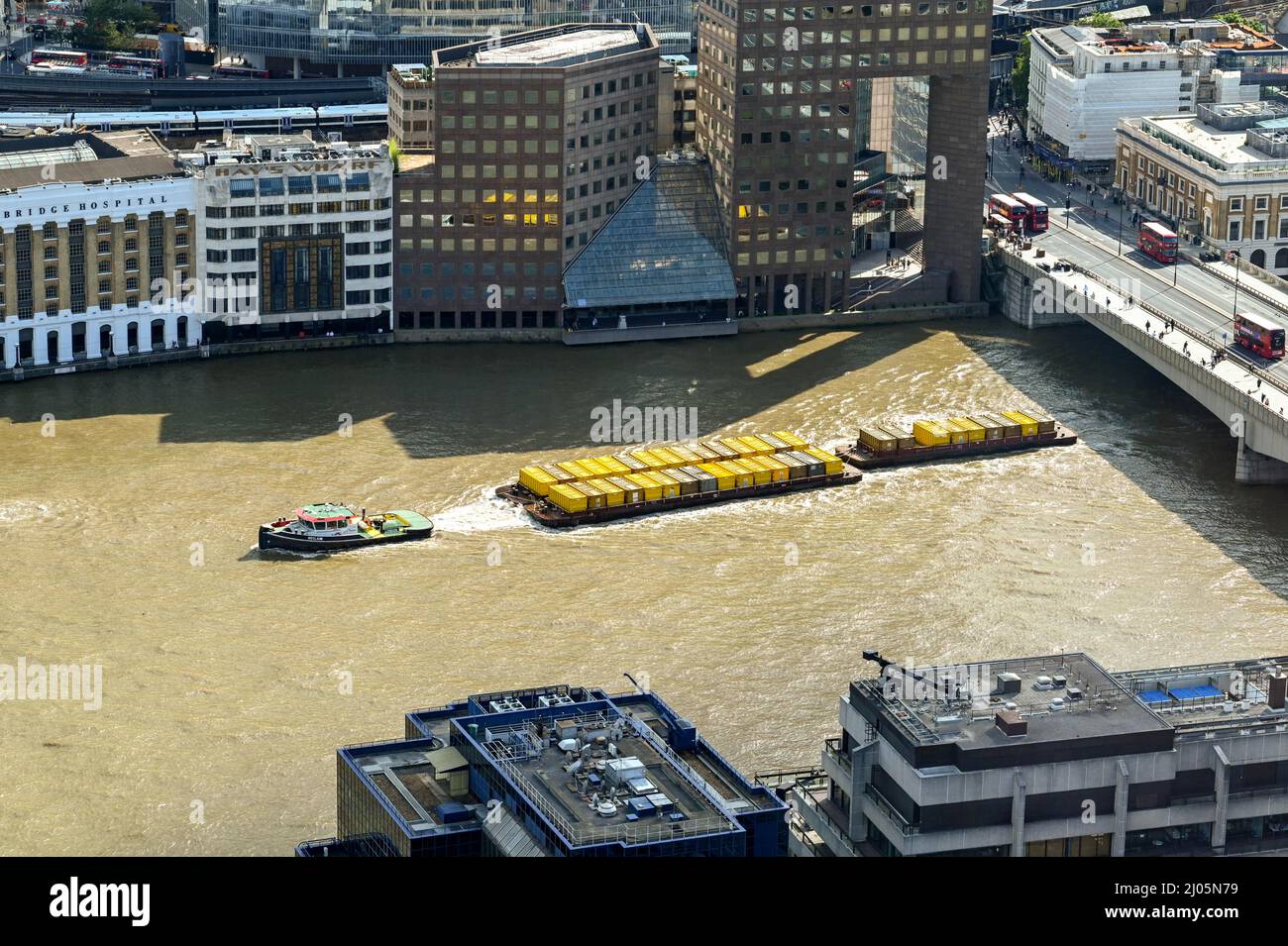 London, England - August 2021: Aerial view of a tug pulling heavy ...