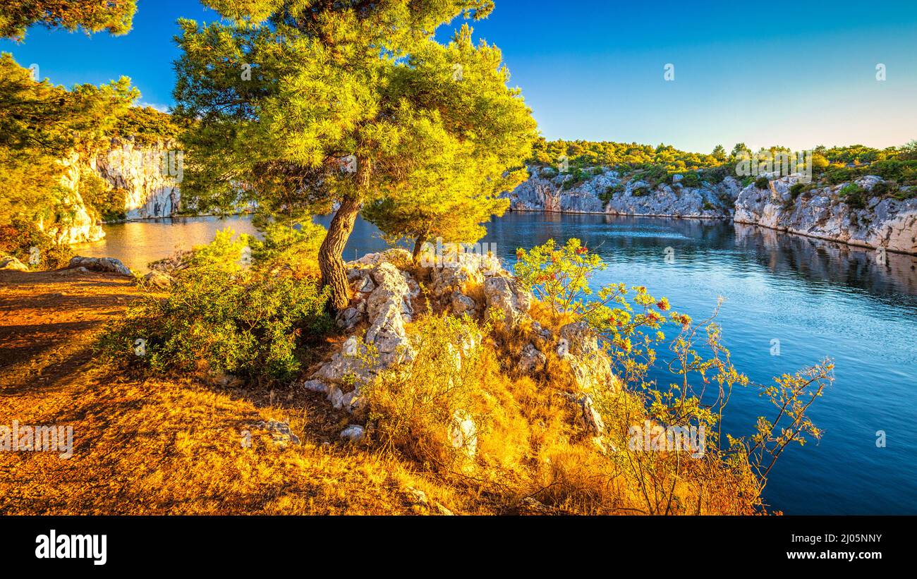 The Zmajevo oko, Dragon's Eye lake at sunset. The Rogoznica village, a ...