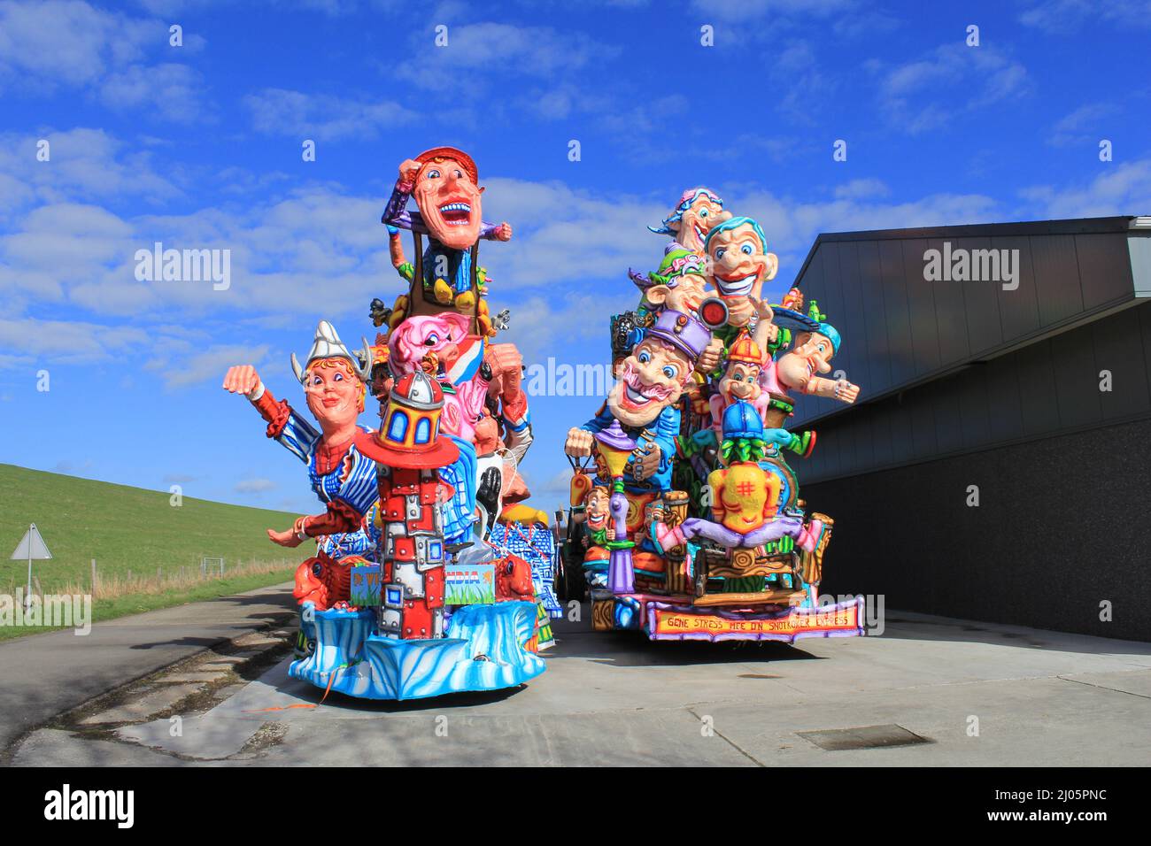 two big colorful floats with puppets for the carnival parade are parked ...