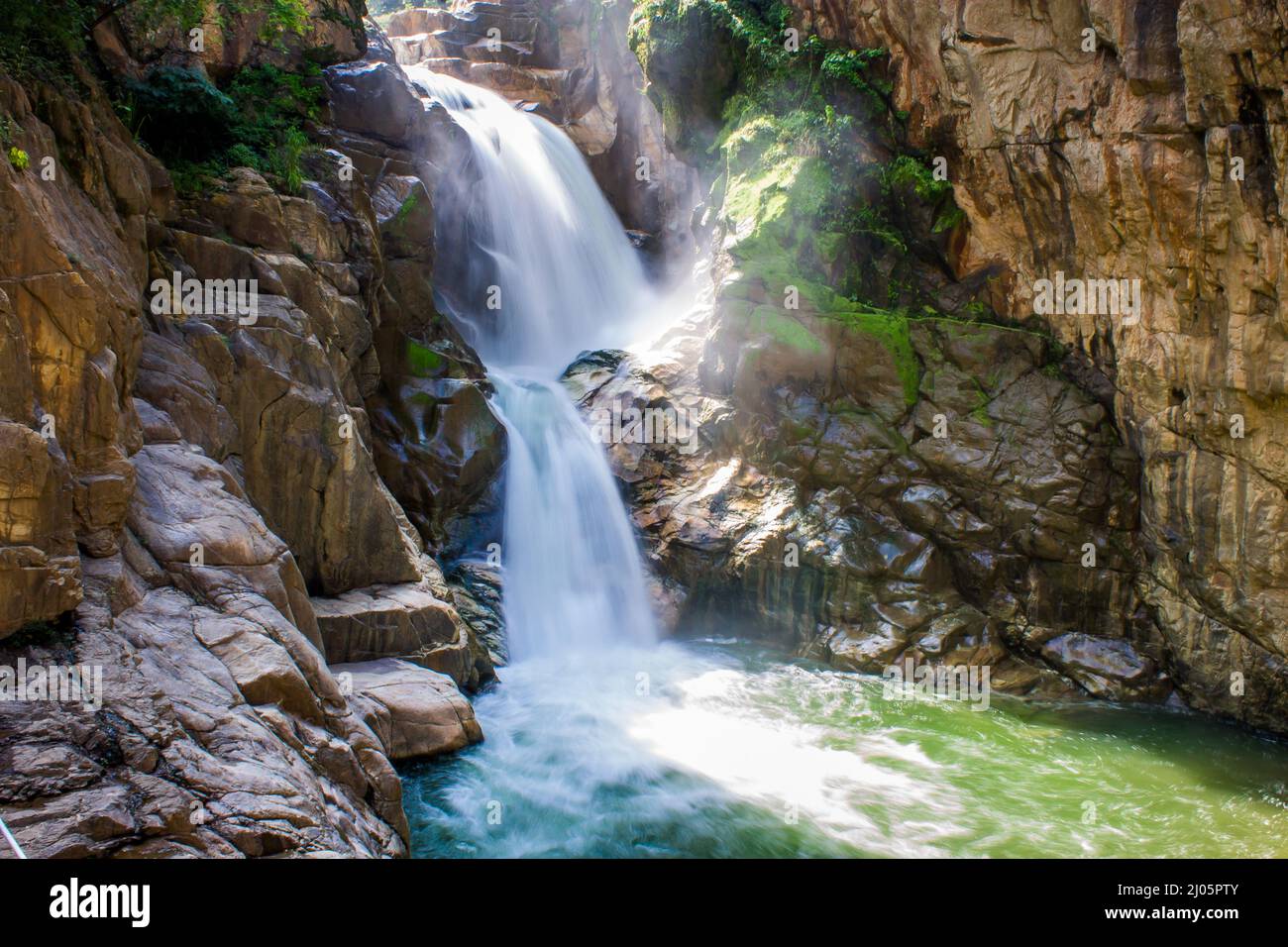 Natural landscape of a remarkable waterfall flowing through the rocks ...
