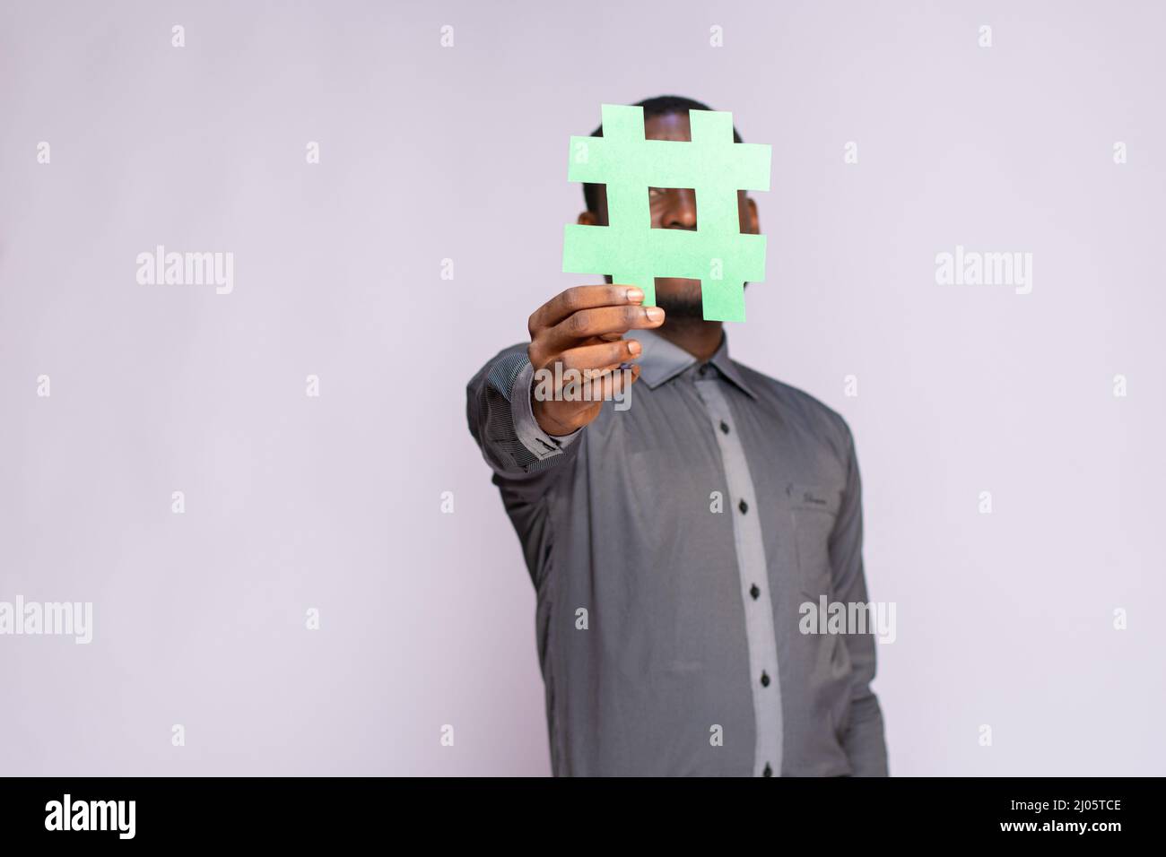 Front view of an African American businessman holding a green hashtag ...