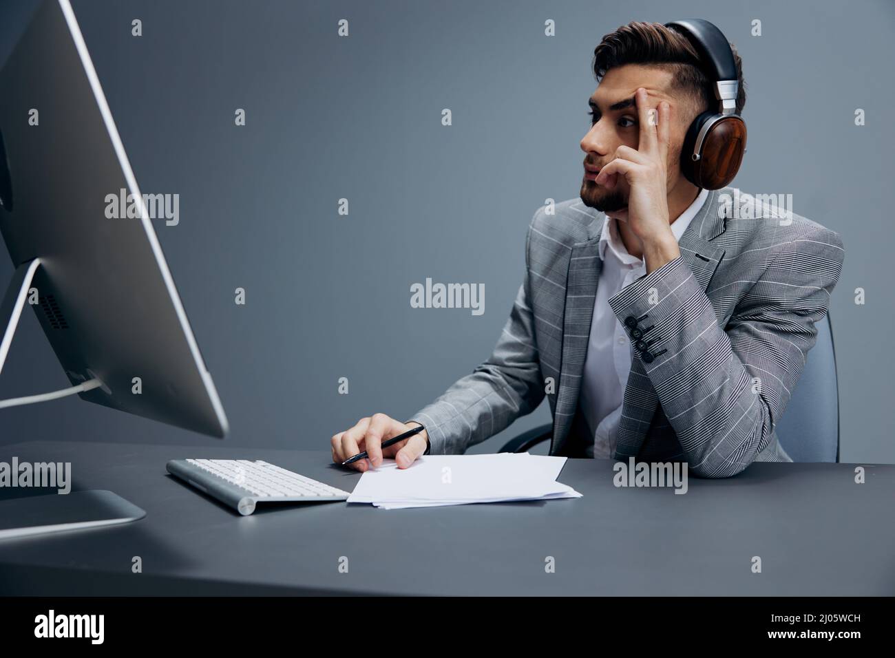businessmen sitting with headphones documents on the table computer ...
