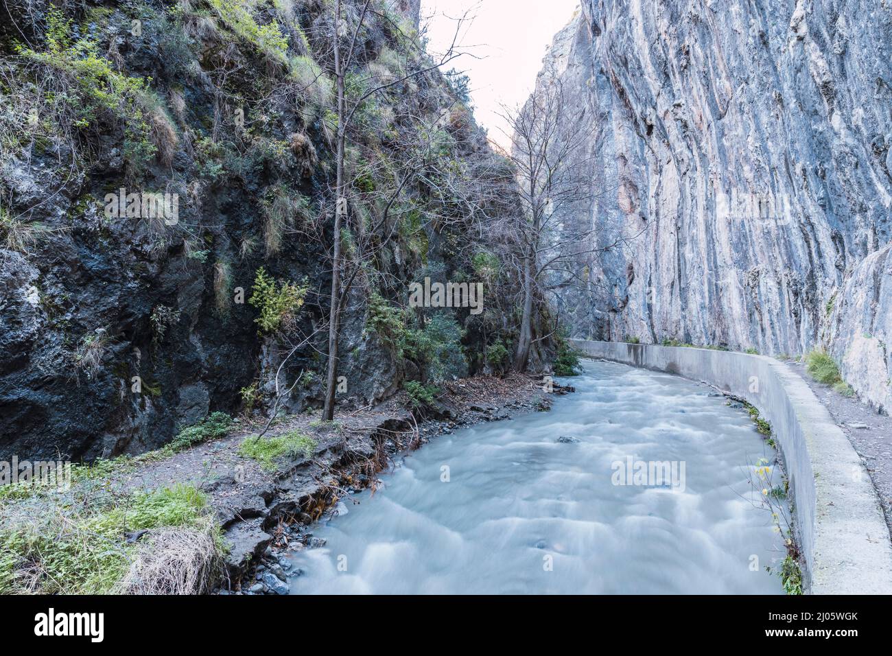 Large water-filled channel between mountain walls on the route of the ...