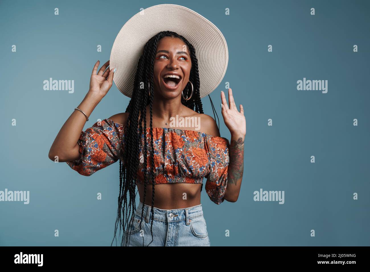 Happy smiling african american young woman standing over blue ...