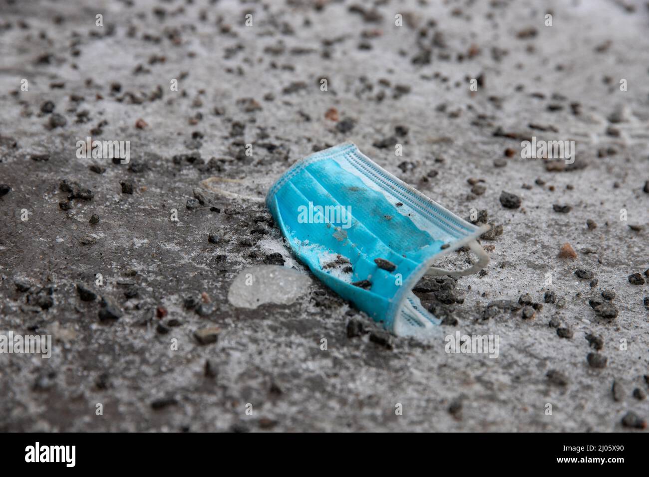 Closeup shot of a dirty medical mask on the ground - pollution with ...