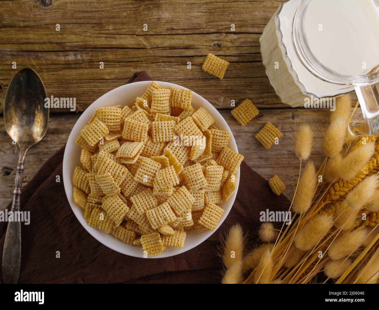 View from above. On a wooden table is a bowl of crispy whole grain pads ...