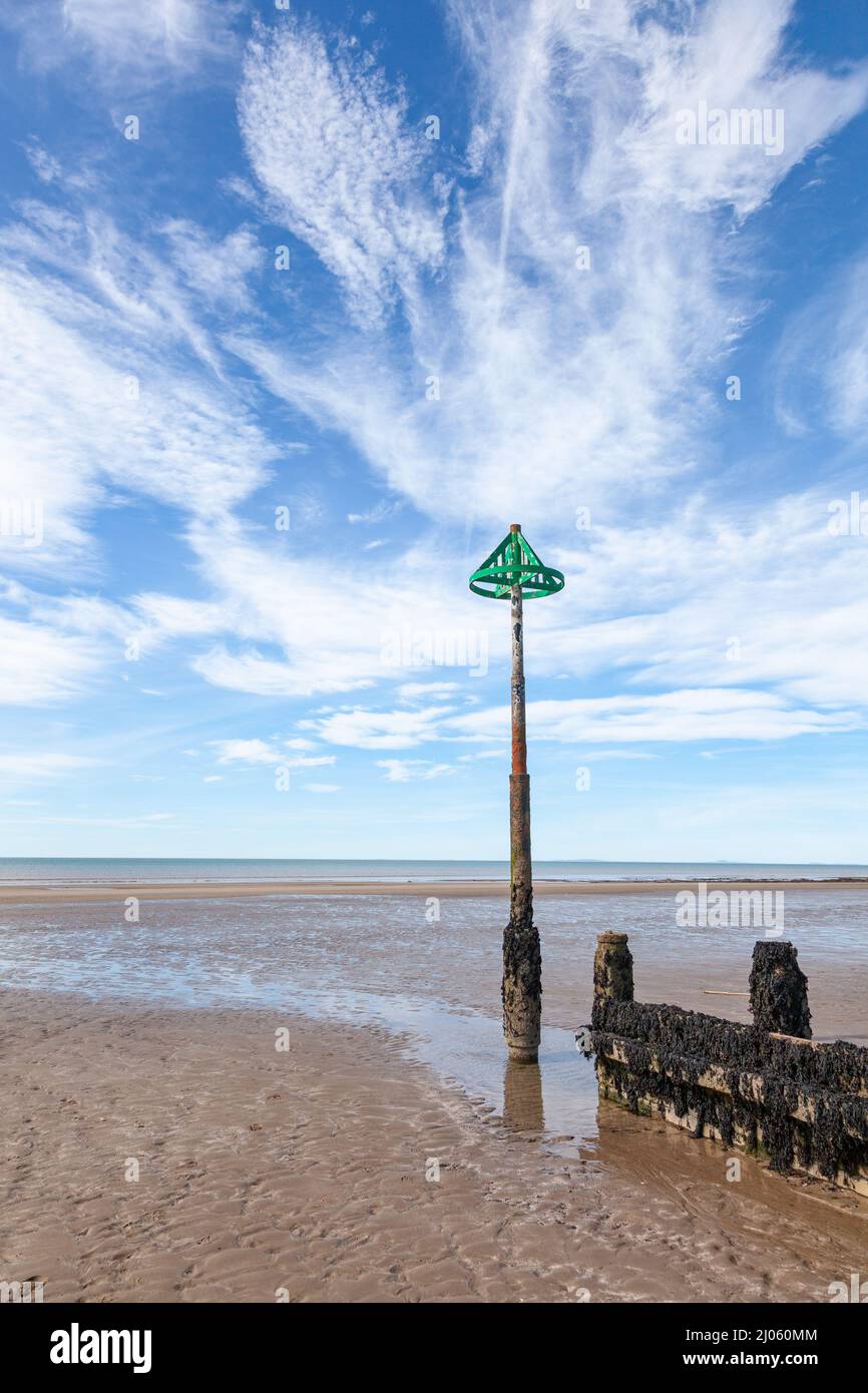 Wooden groyne and tall end of groyne marker on sand beach against ...
