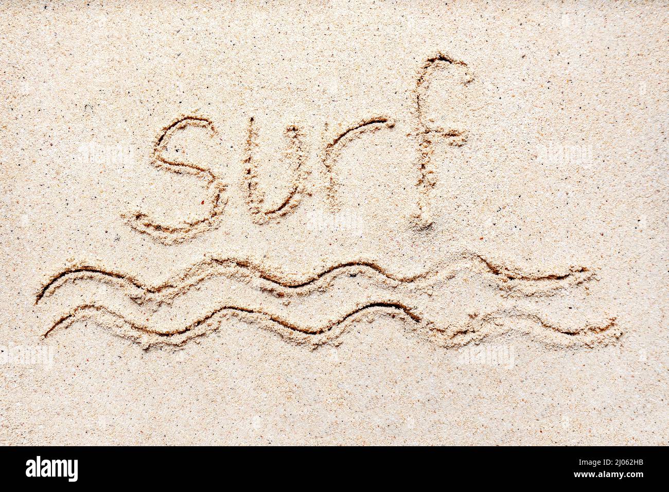 Handwriting words "Surf" on sand of beach Stock Photo - Alamy