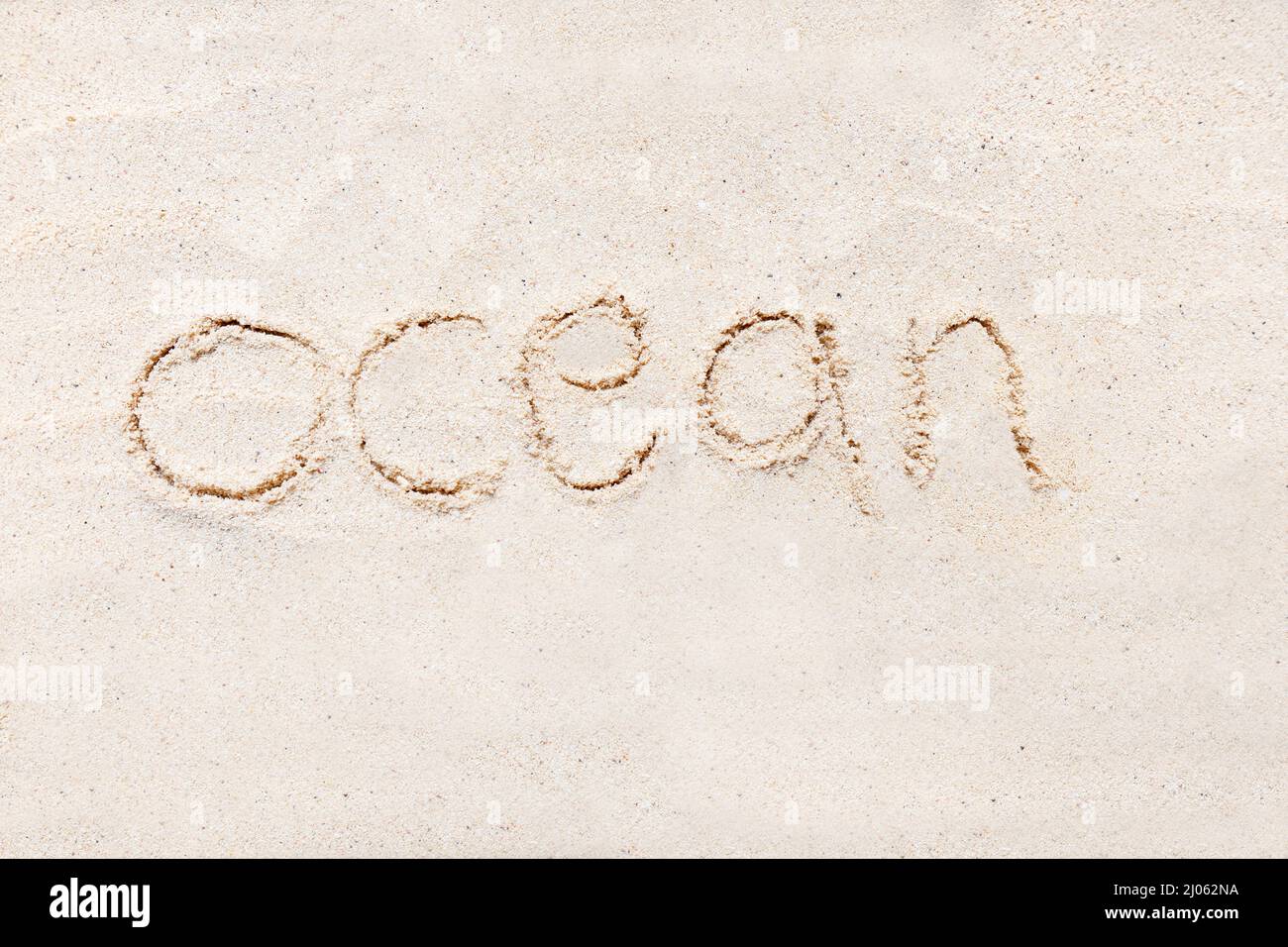 Handwriting words "ocean" on sand of beach Stock Photo - Alamy