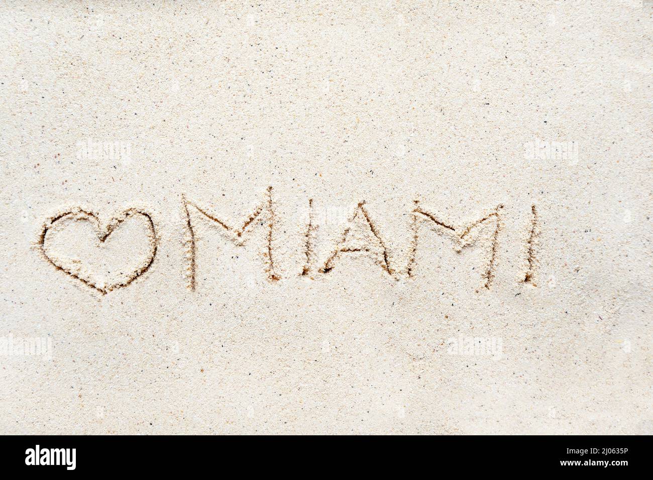 Handwriting words "Miami" on sand of beach Stock Photo - Alamy