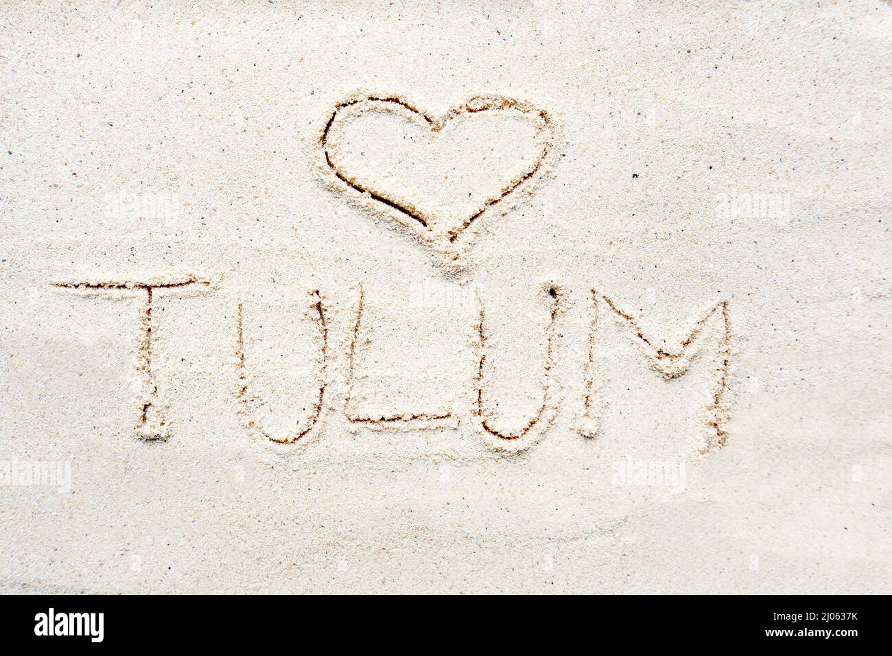 Handwriting words "Tulum" on sand of beach Stock Photo - Alamy
