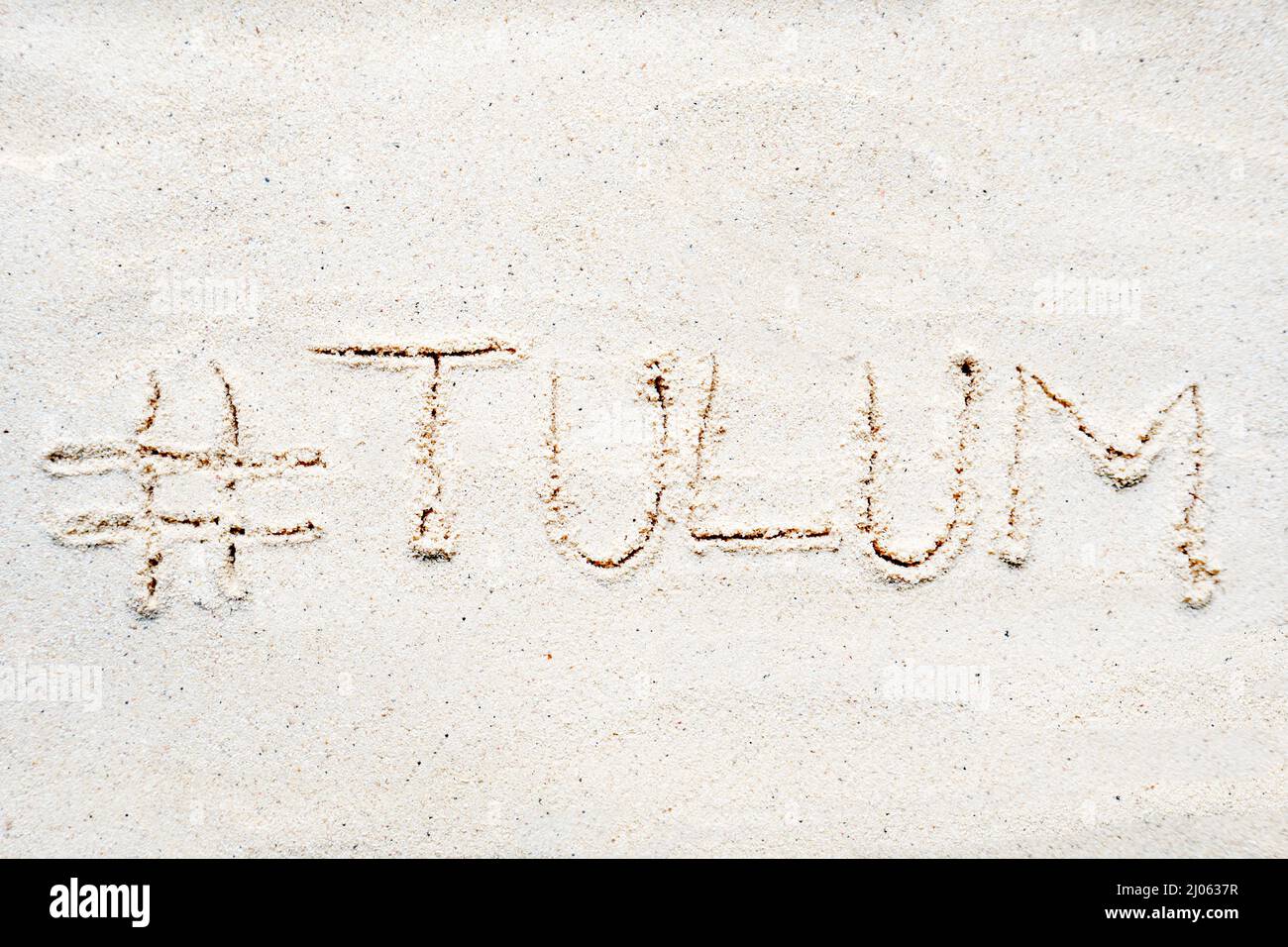 Handwriting words "Tulum" on sand of beach Stock Photo - Alamy