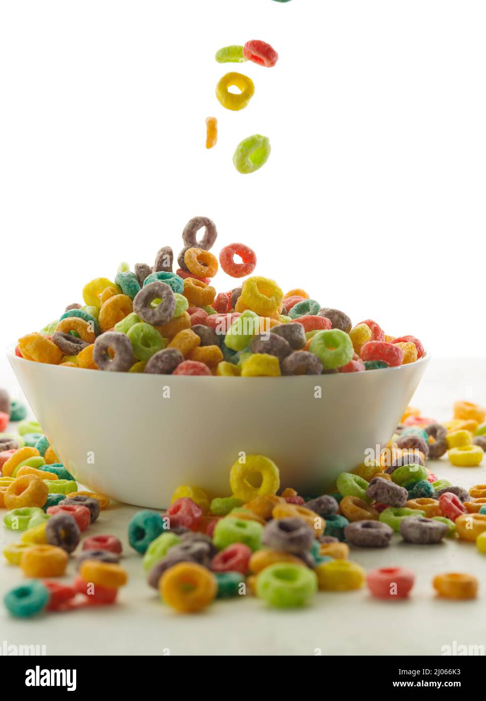 Cereal crispy multi-colored rings in a bowl and near it on a white ...