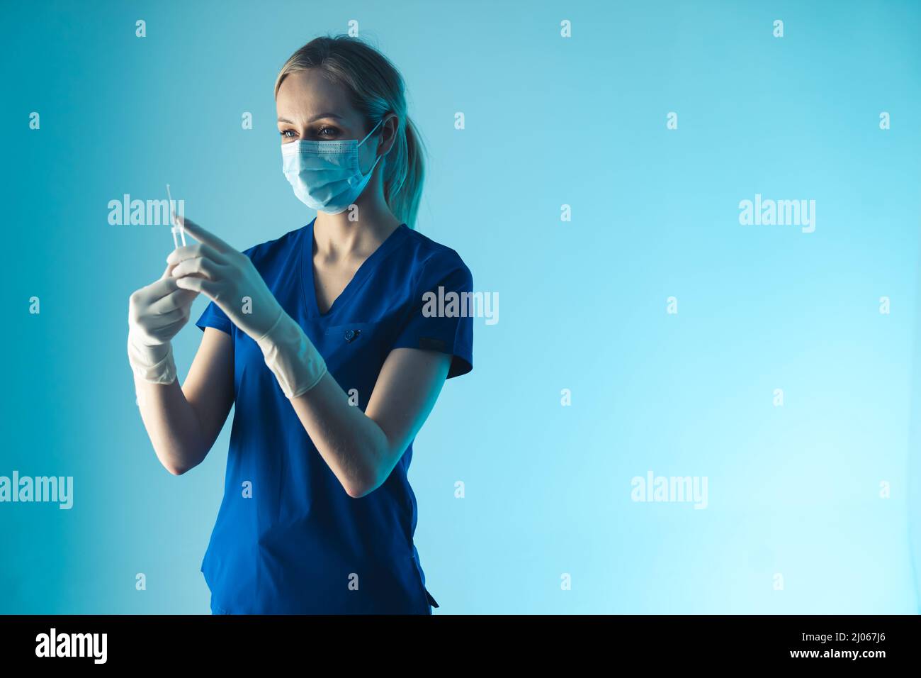 Masked caucasian doctor wearing a uniform with an injection in her ...