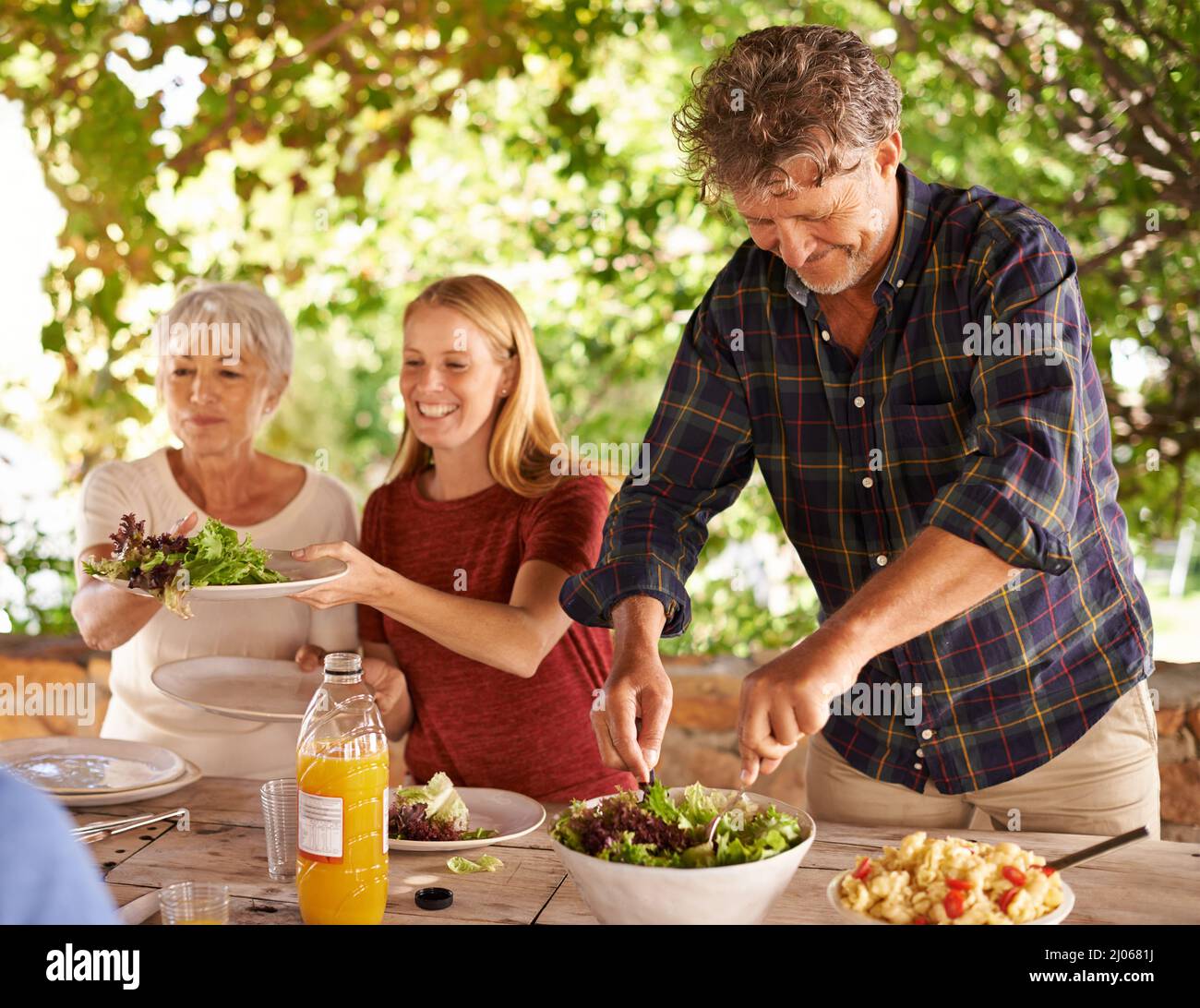 Dads in charge of dishing up. A view of a family preparing to eat lunch ...
