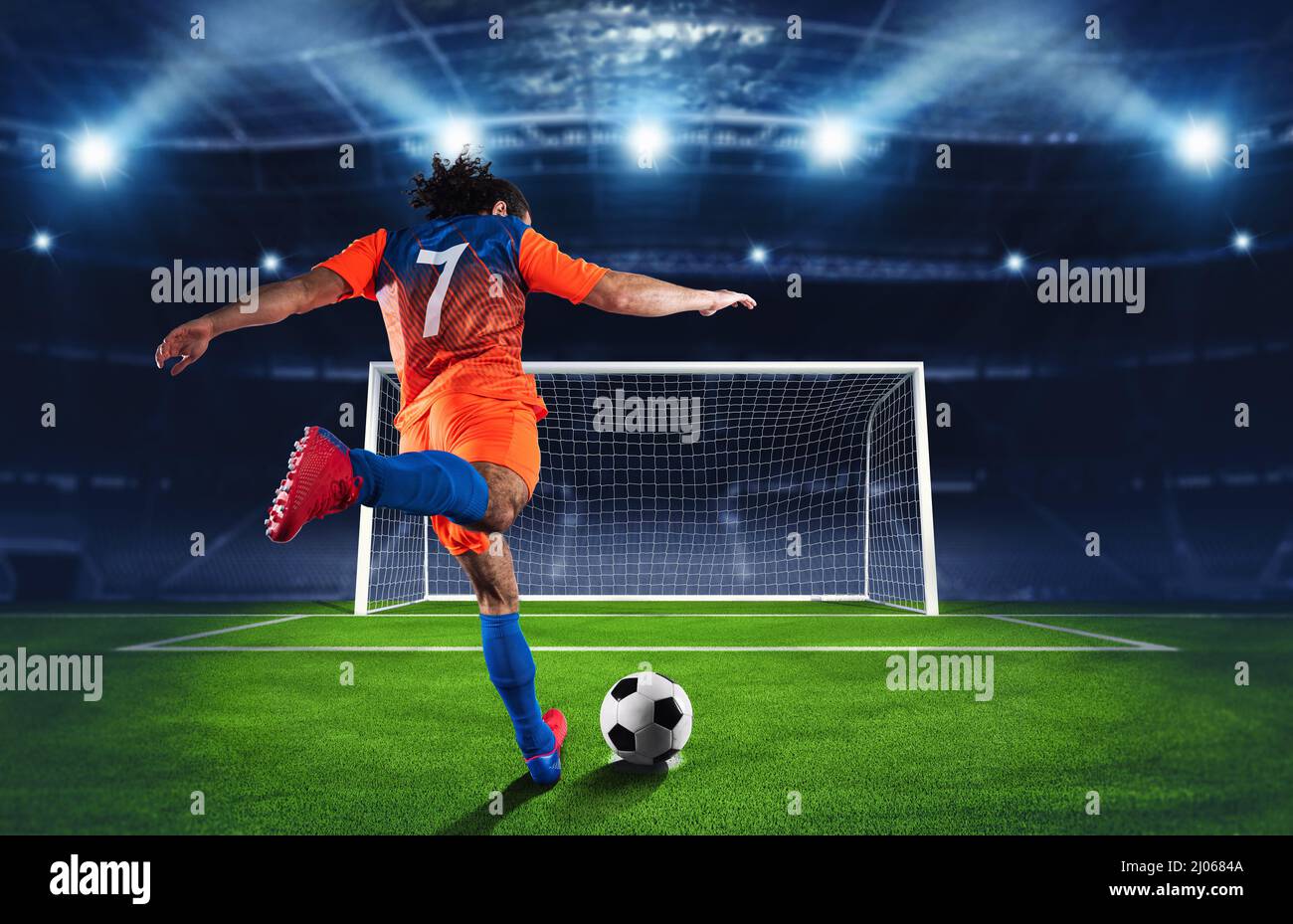 Soccer scene at night match with player in an orange and blue uniform ...