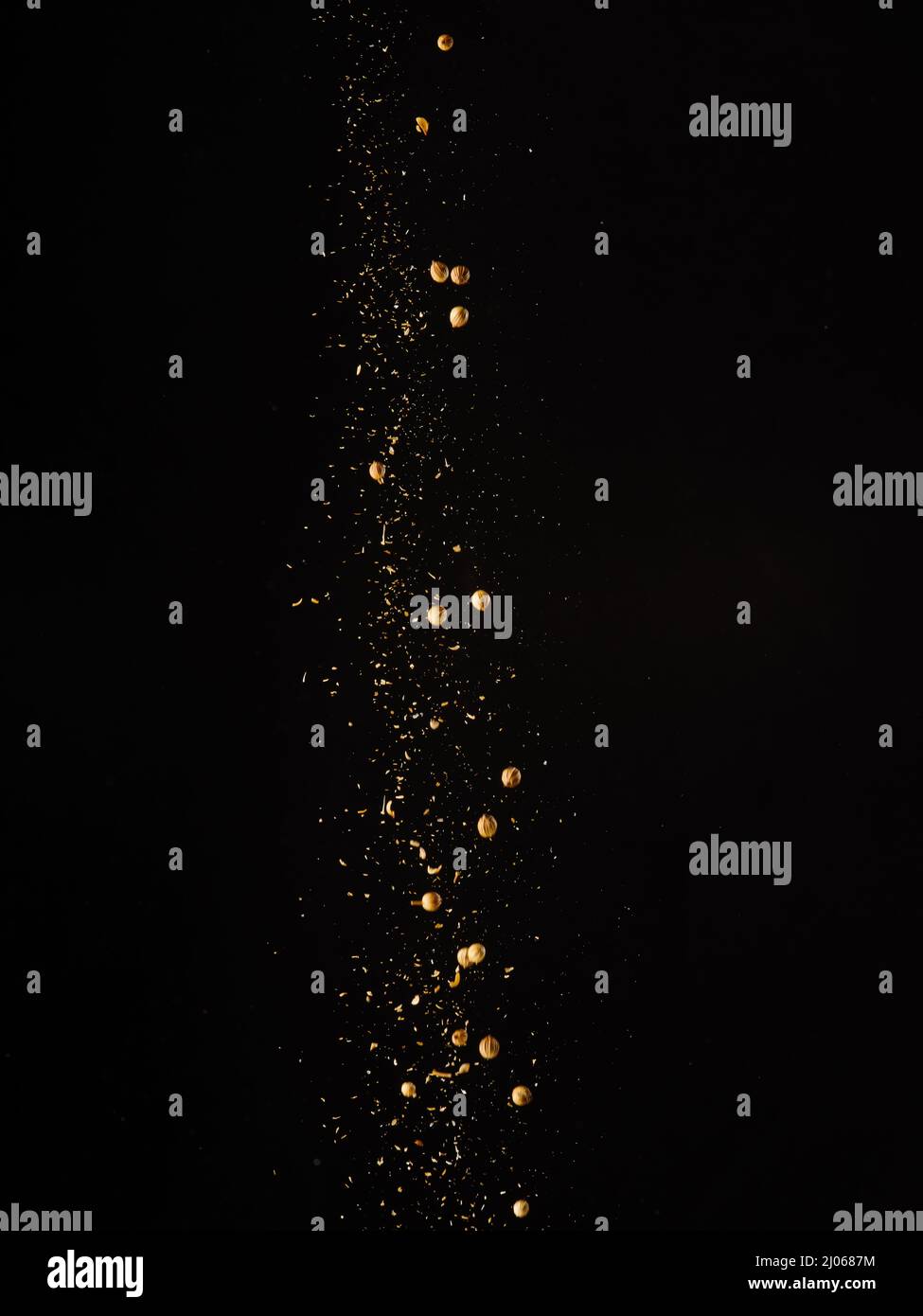 A stream of golden colored spices in a frozen flight isolated on a ...