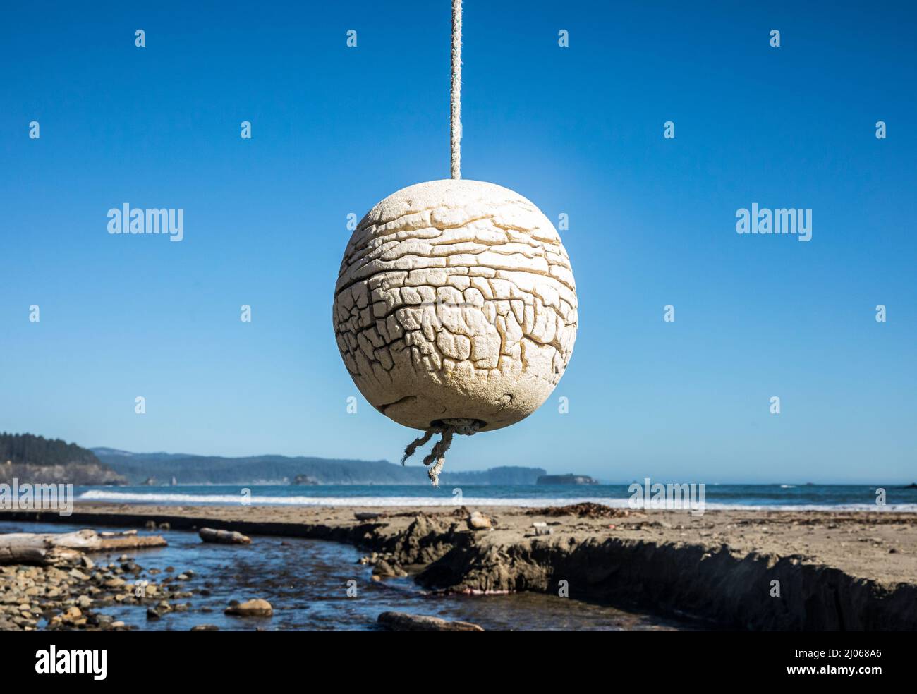 Some sort of foam type float weathered / cracked and hanging by a rope ...