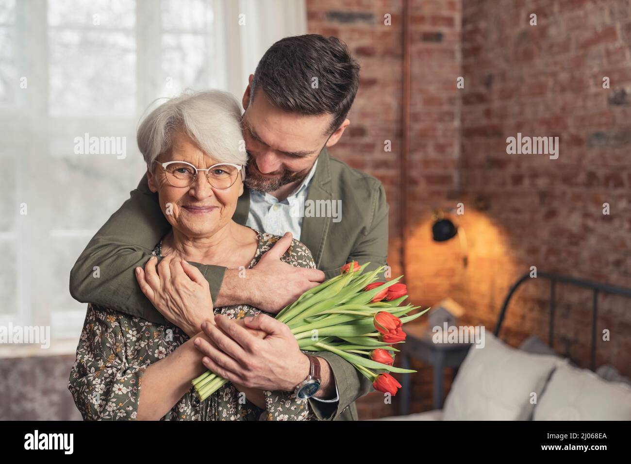 medium shot of elderly happy grandma with her middle-aged grandson ...