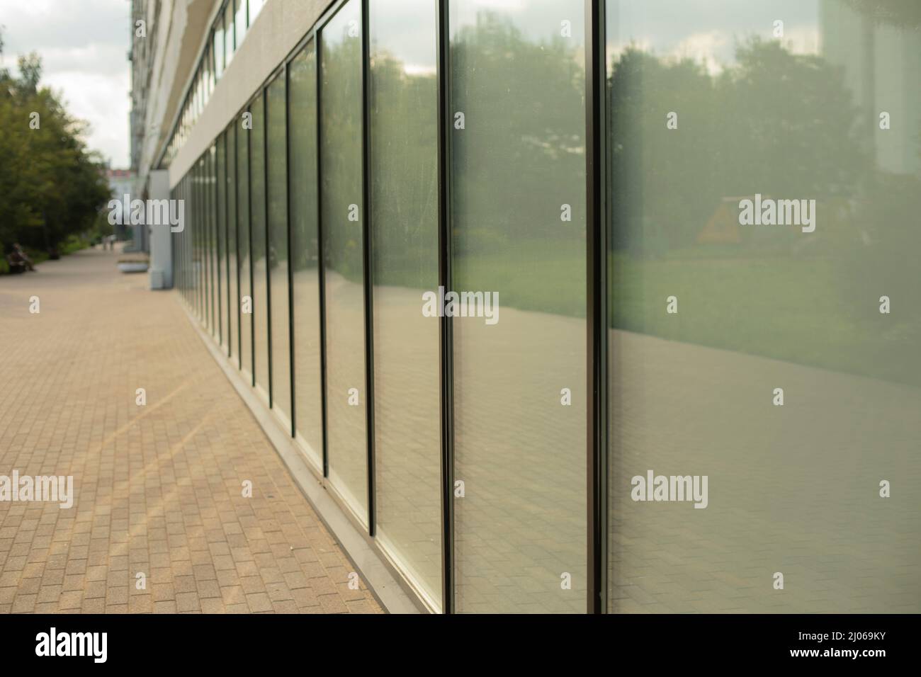 Facade glass in a long house. A row of window frames. Shop window ...