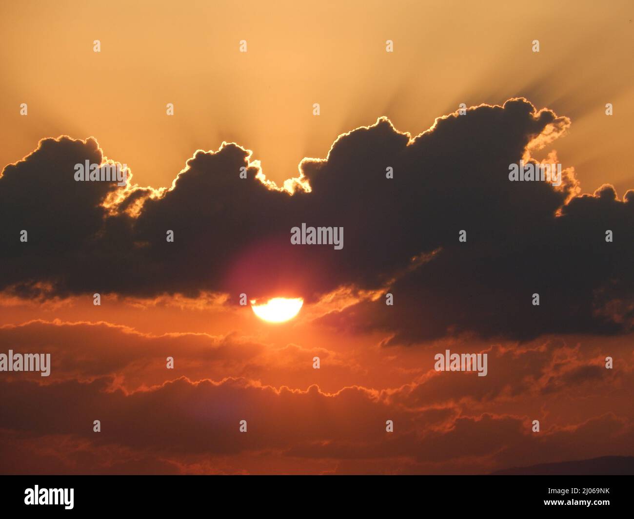 Flaring Sun Behind Outlined Cloud Stock Photo - Alamy