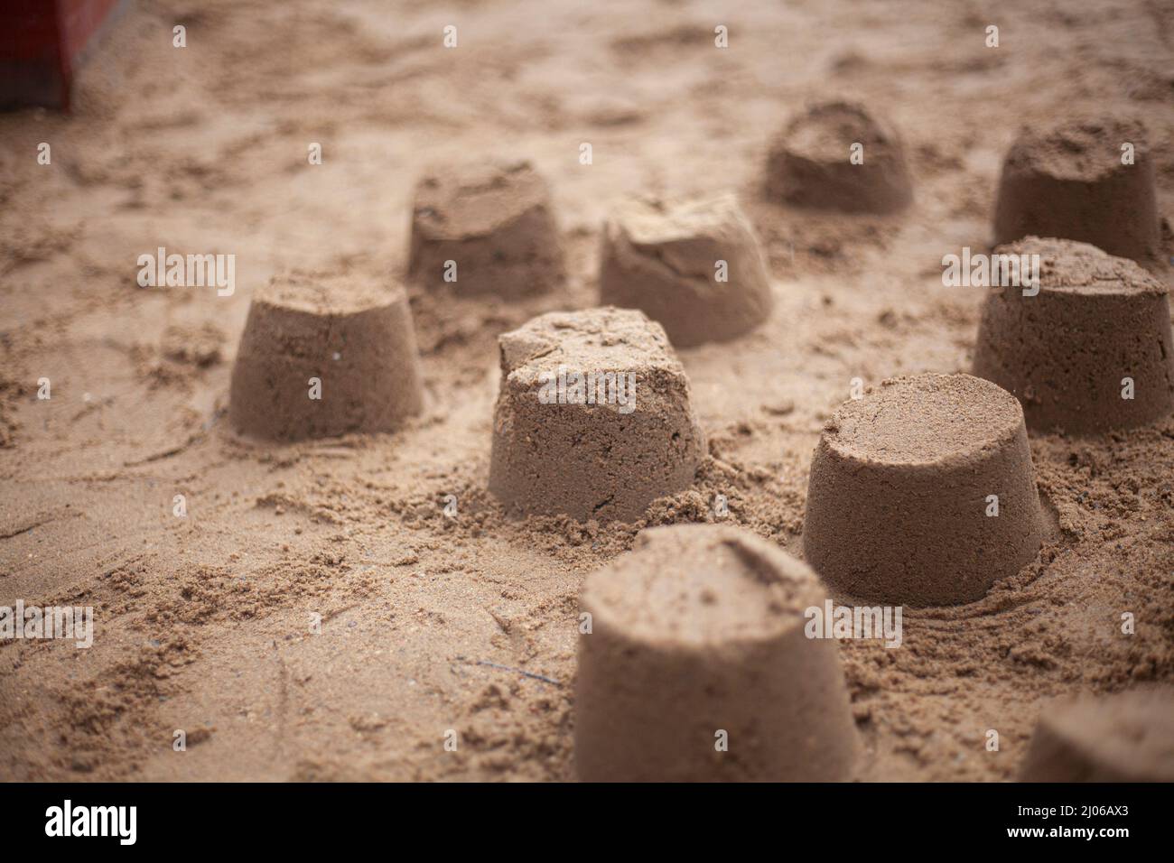 Sand cakes in sandbox. Lot of objects made from stove. Result of ...