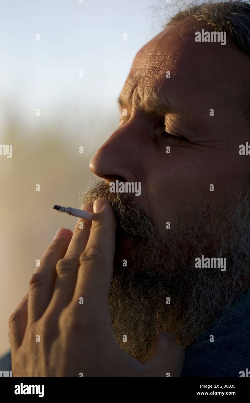 Bearded Man Smoking a Cigarette Stock Photo - Alamy