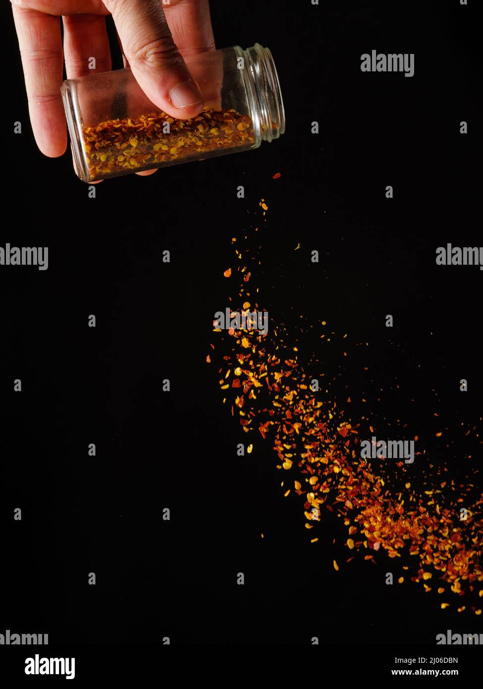 A jar of seasonings, spices in a female hand. Spices in frozen flight ...