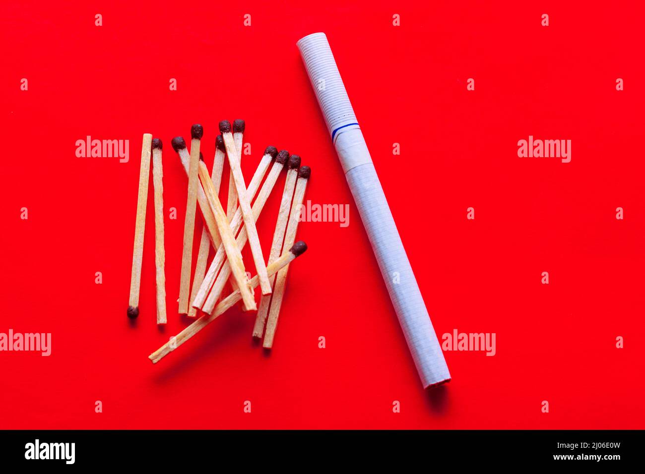 Tobacco cigarette and matches , red background Stock Photo - Alamy