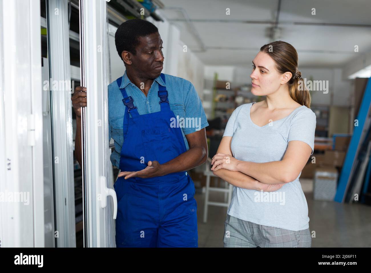 Portrait of man worker who is consultating woman about windows in the ...