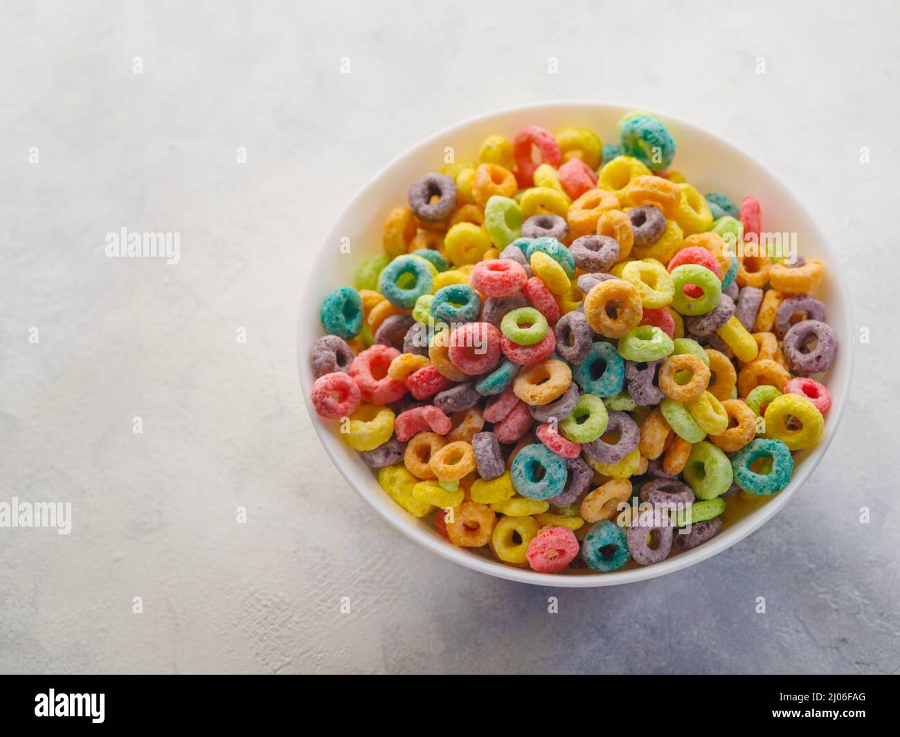 Crispy multi-colored corn rings in a bowl on a white background. Close ...