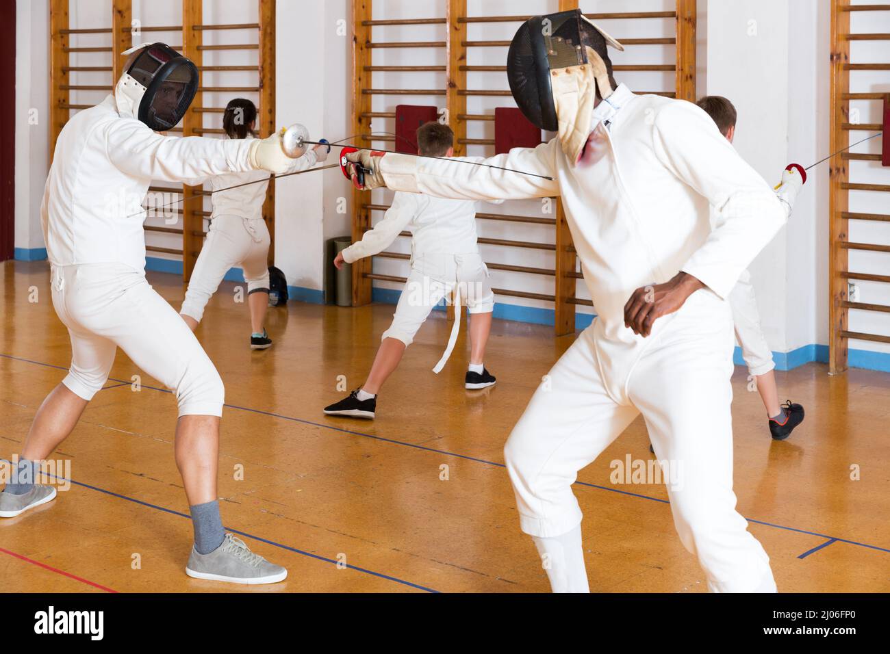 Portrait of children and adults fencers with coaches engaged in fencing ...