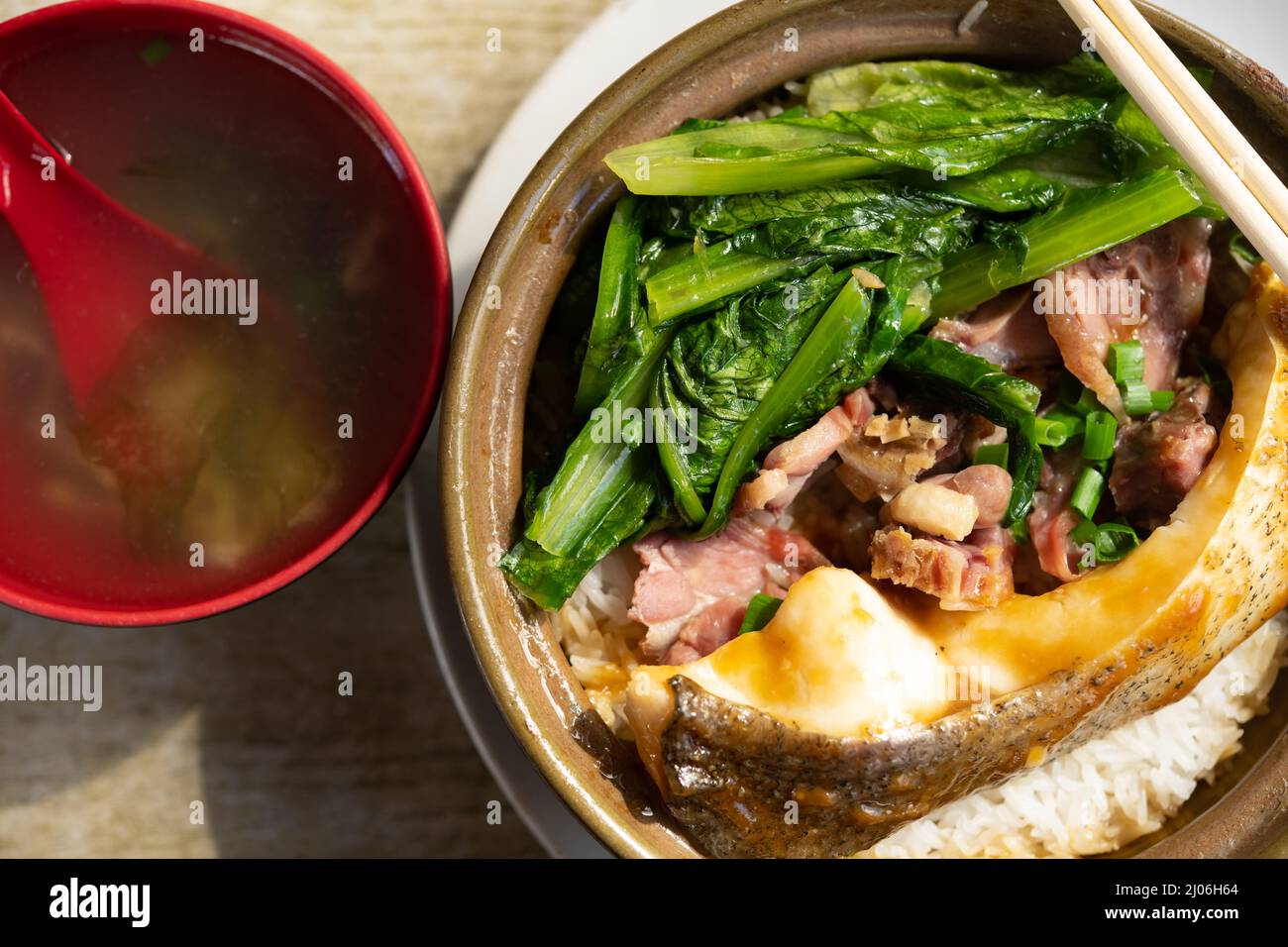 top view clay pot rice with fish and pickled duck and vegetable ...