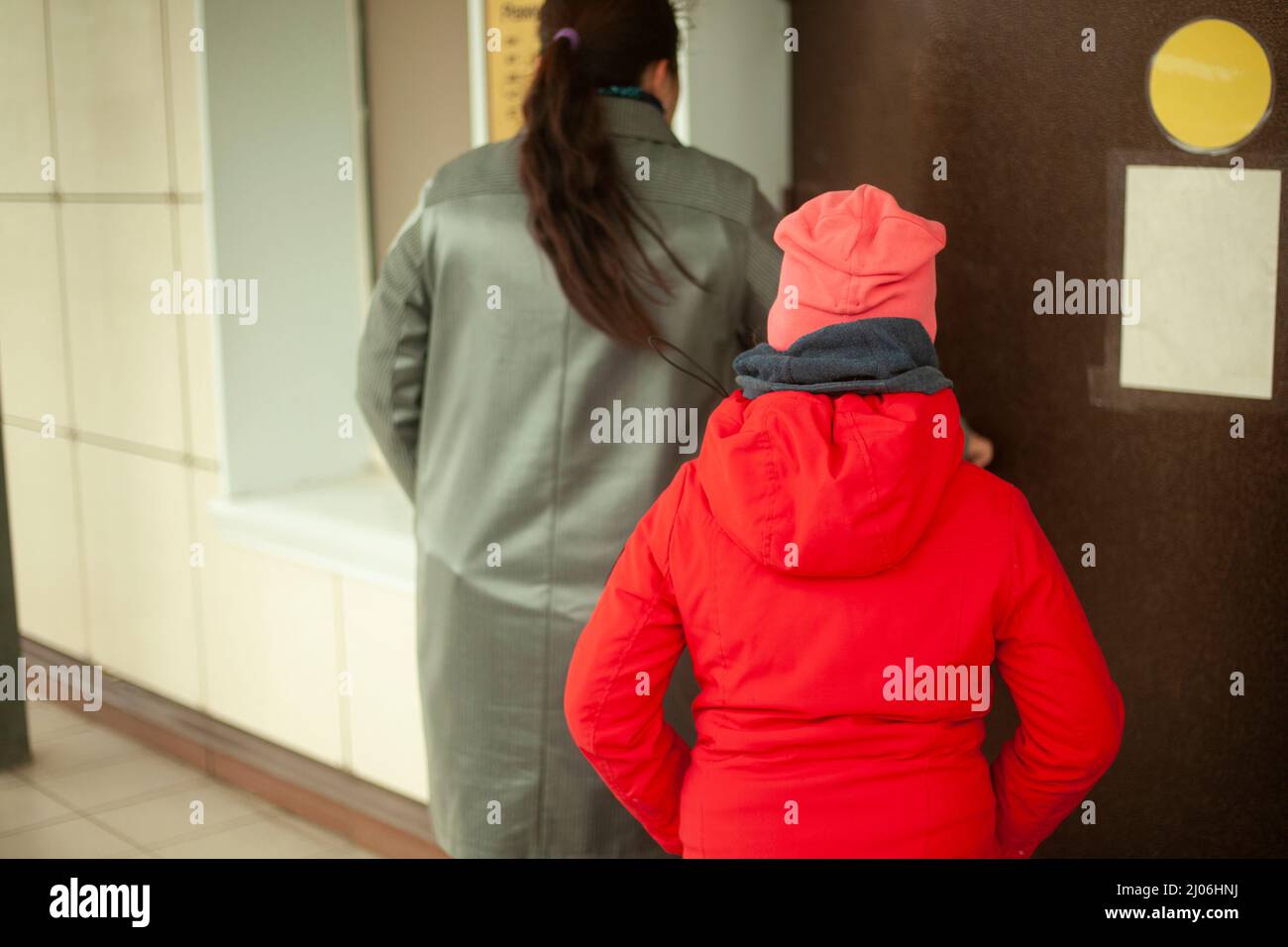 People walk into administration building. Woman opens door. Man on ...