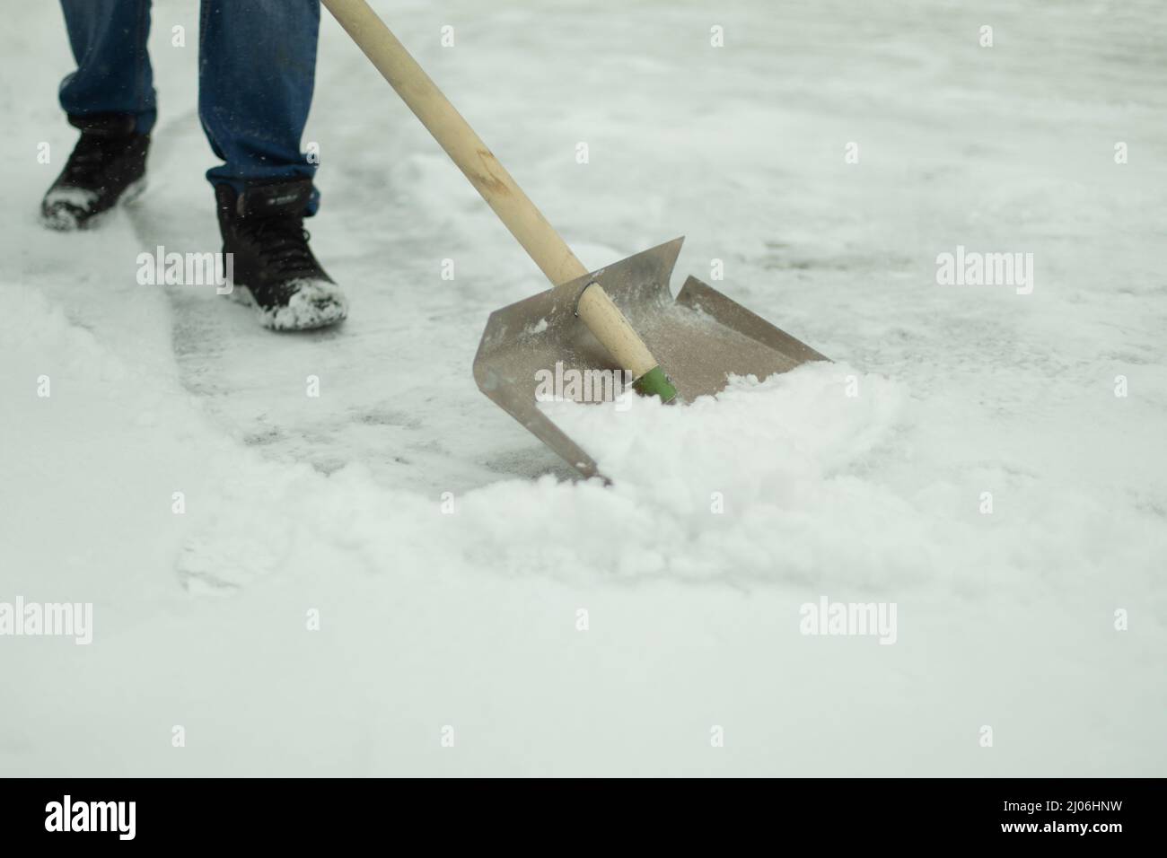 Shovel snow removal. Tool for cleaning snowdrift. Janitor cleans road ...