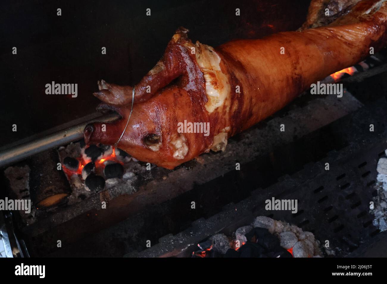 Pig being grilled slowly on spit cooked with charcoal Stock Photo - Alamy